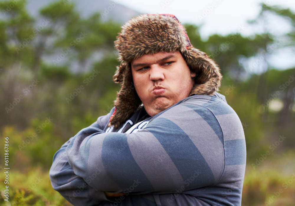 Angry, frustrated and young overweight man in nature during winter ...