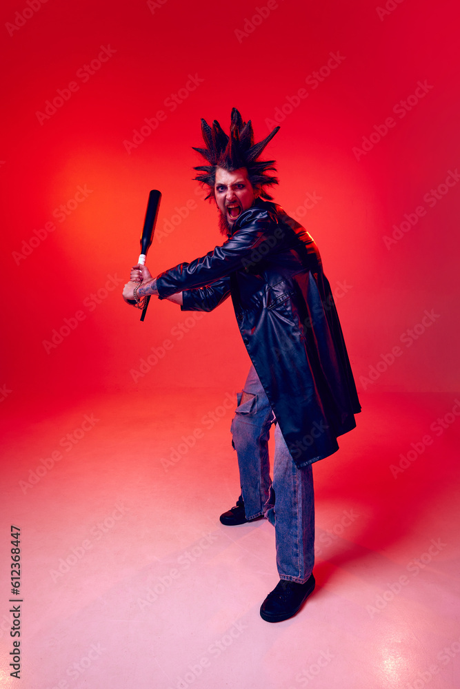 Expressive young man, punk with weird hairstyle and makeup ...