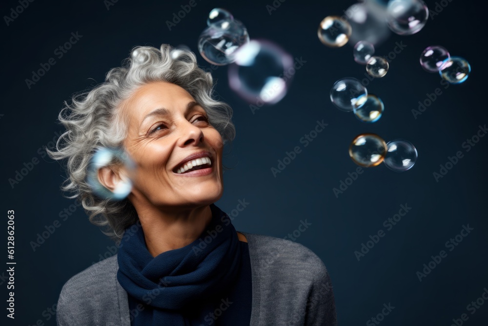 Headshot portrait photography of a happy mature woman blowing bubbles ...