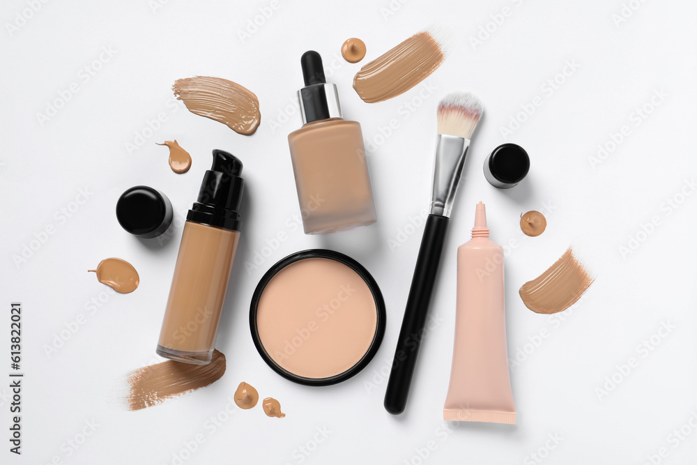 Liquid foundations, makeup brush, swatches and face powder on white ...