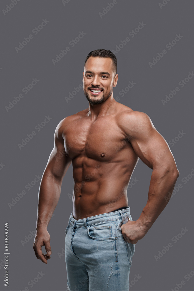 Charming and muscular male model with a dazzling smile poses shirtless ...