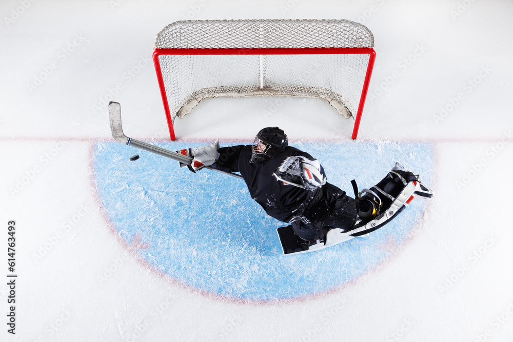 Overhead view hockey goalie reaching to block puck at goal net Stock ...