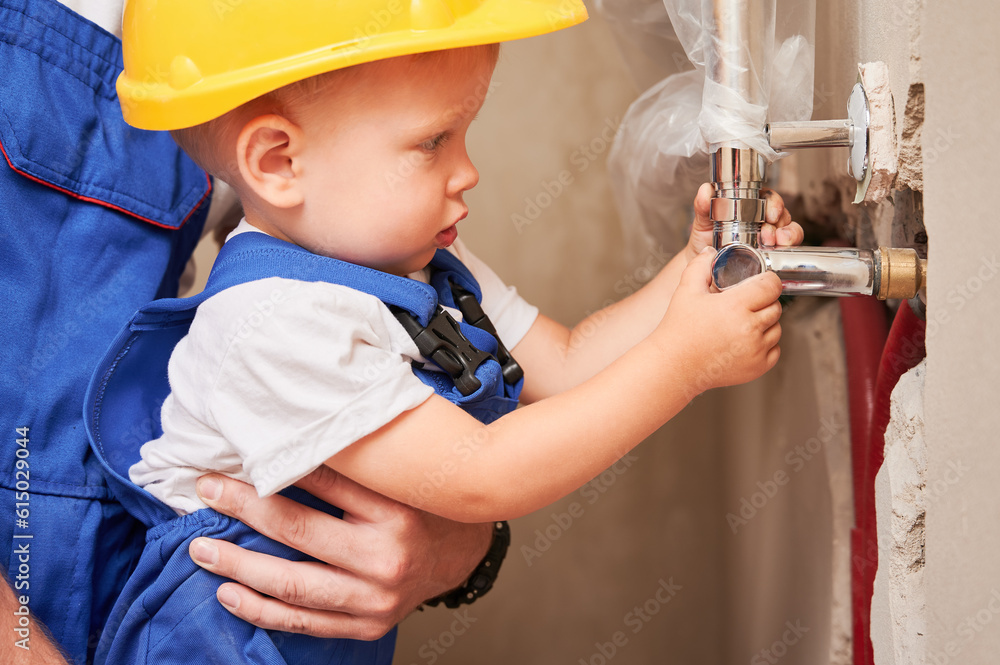 Close up of father holding little son while child installing plumbing ...