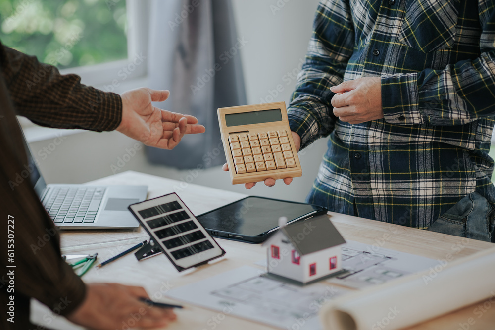 Engineer working in office at desk with solar laptop and concept home ...