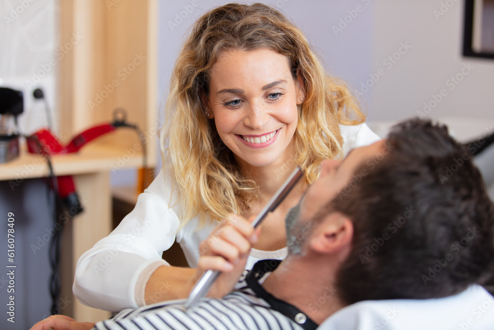 female barber trims a mans beard Stock Photo | Adobe Stock