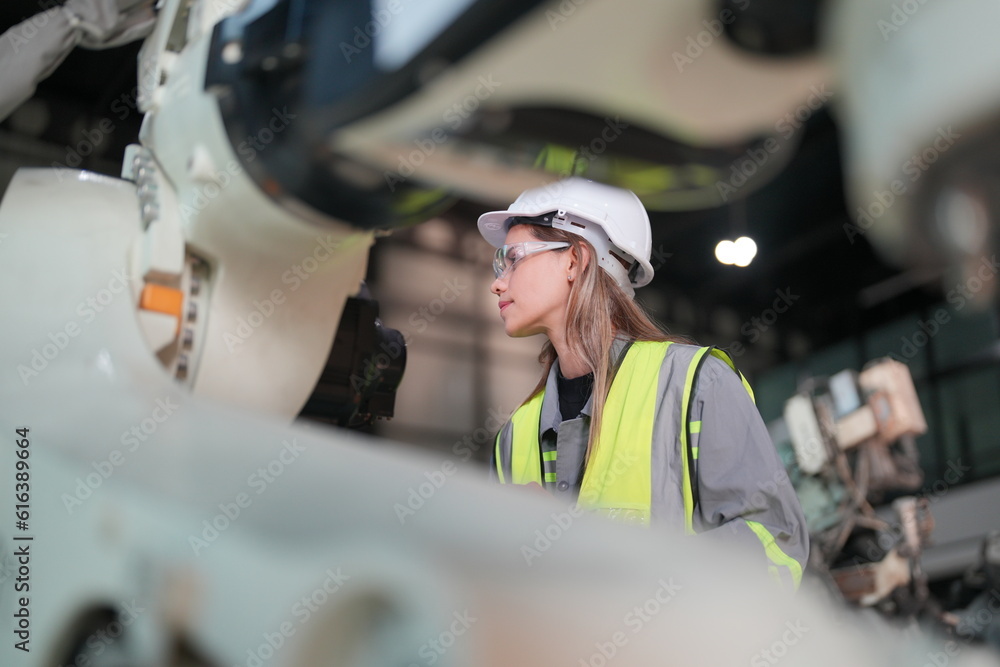 Female Automotive Engineer Wearing Hard Hat, Standing, Using Laptop ...