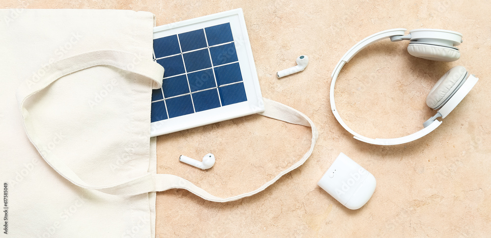Bag with portable solar panel, wireless earphones and headphones on ...