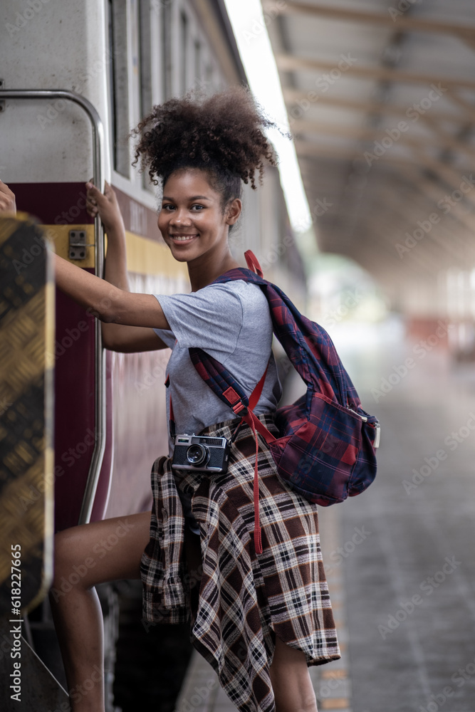Traveler african asian american woman getting in a train to hop on ...