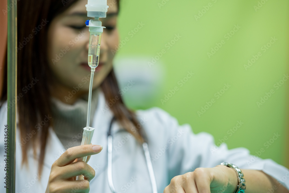 Woman doctor monitor Adjust the drip rate feed of saline dripping ...