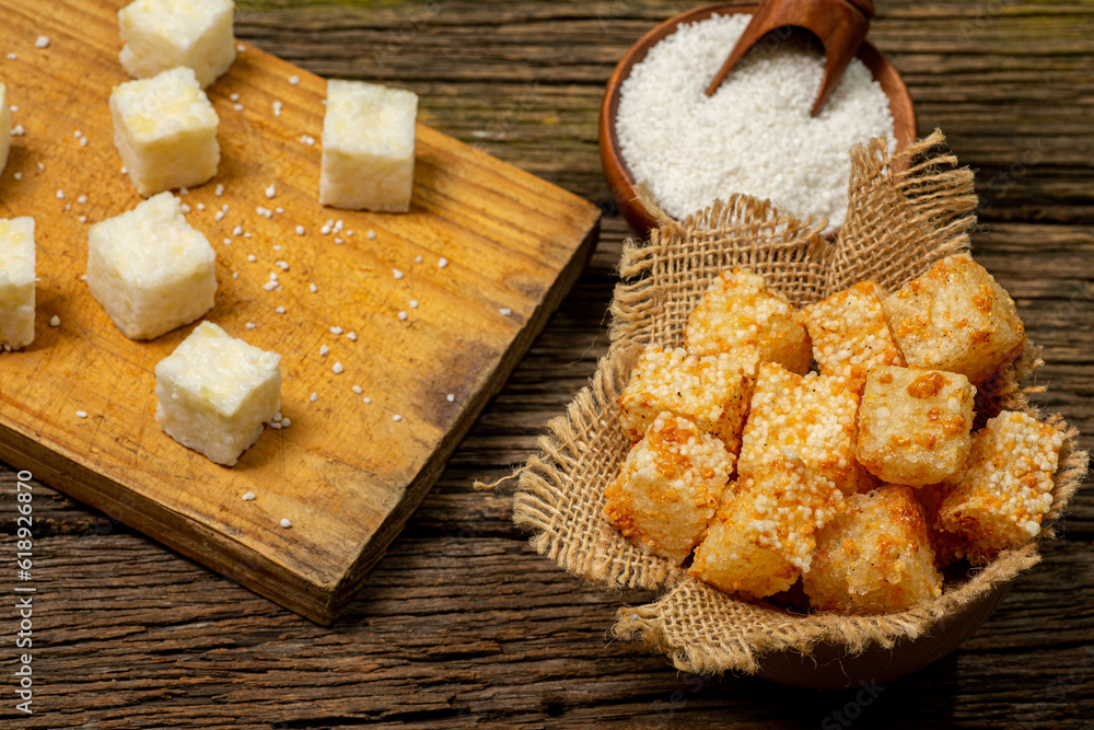 Raw and fried tapioca cubes (Dadinhos de Tapioca) on top of rustic ...
