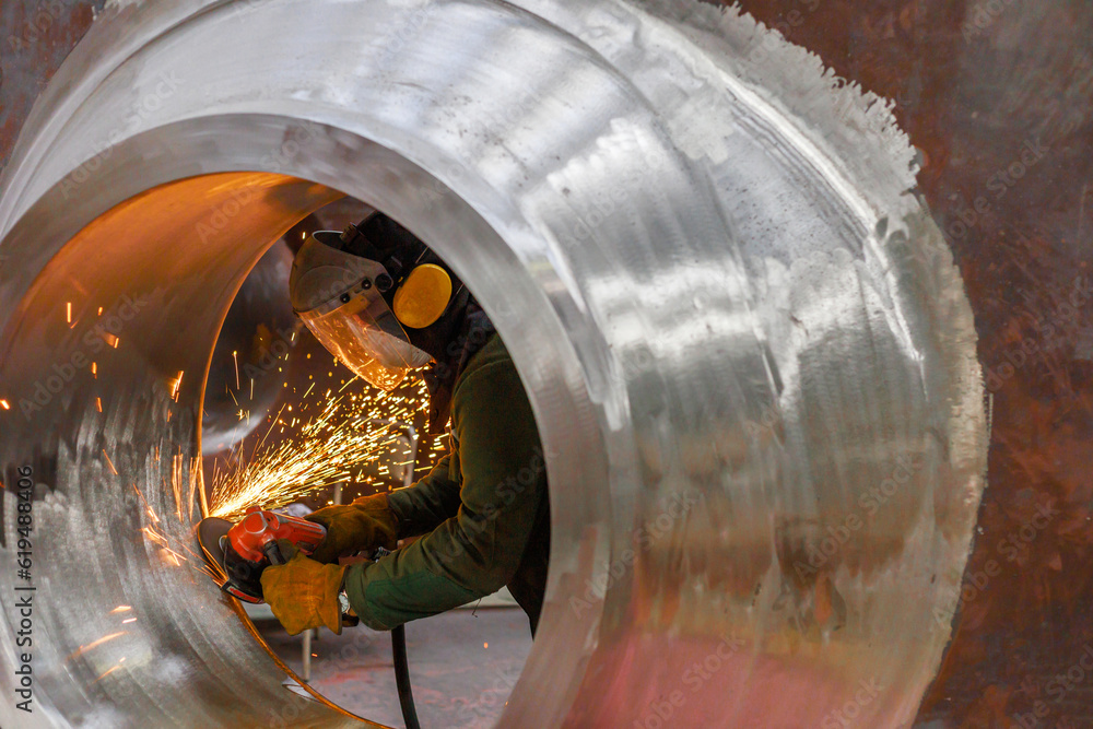 A worker processes nozzle of the reactor vessel with special equipment ...