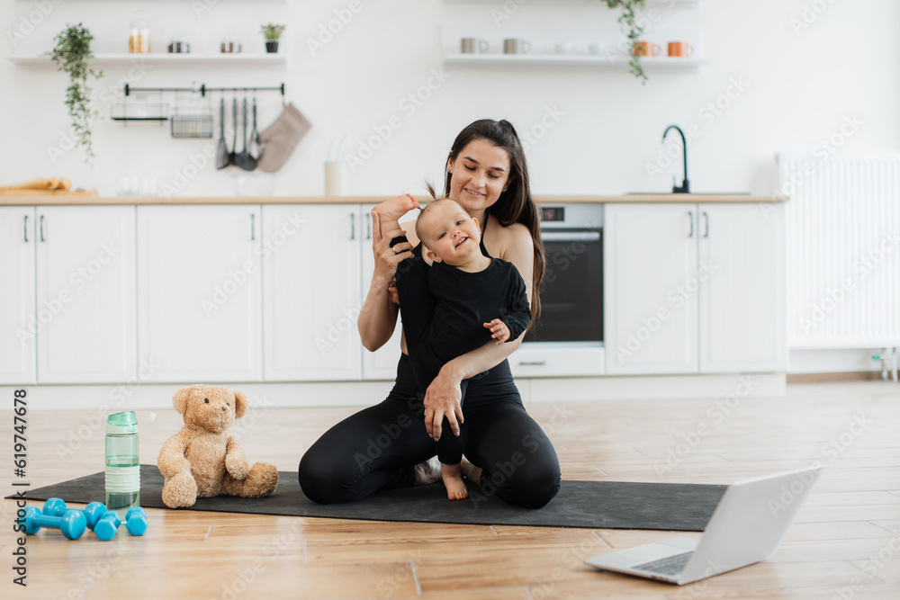 Adorable little child doing splits with mother's support while ...