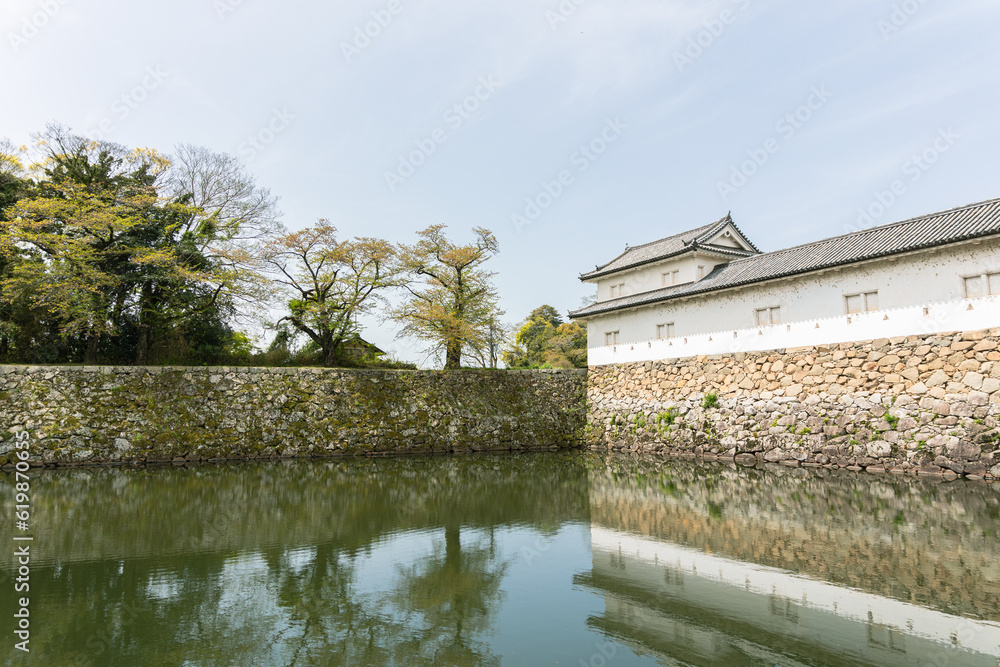 view of the river out of a Japanese castle stone wall, trees and sky in ...