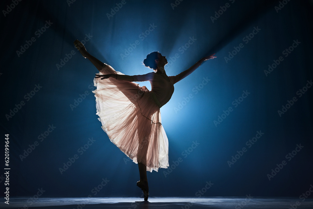Theatrical performance. Beautiful, tender, graceful ballerina dancing against dark blue ...