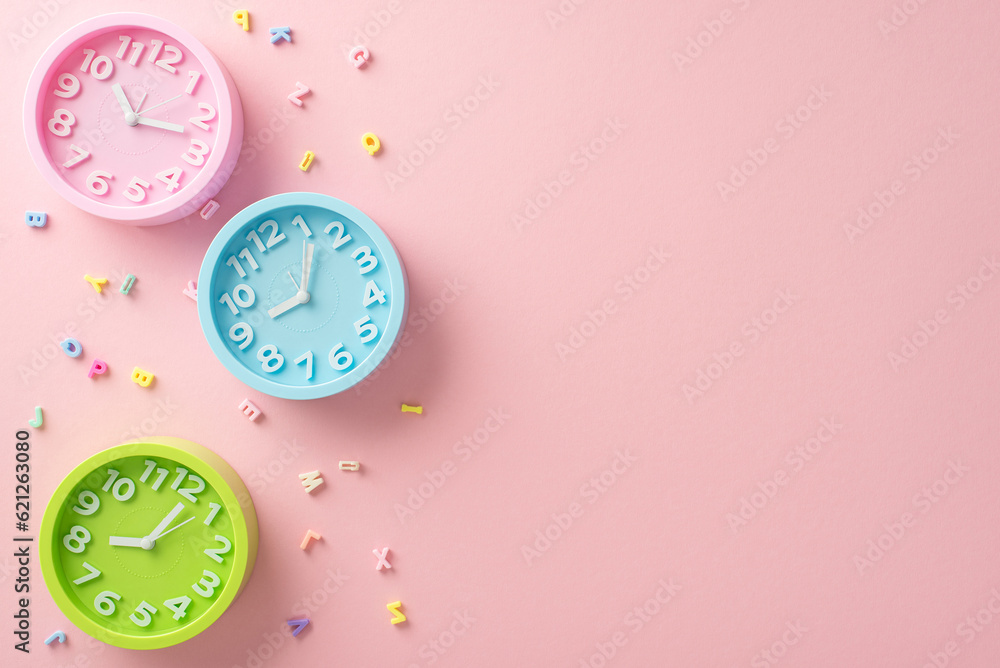 Welcome back to school. Top view of alphabet letters and three clocks ...