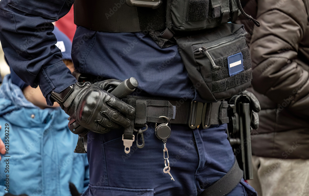 Anonymous police officer holding his hand on his equipment belt ...