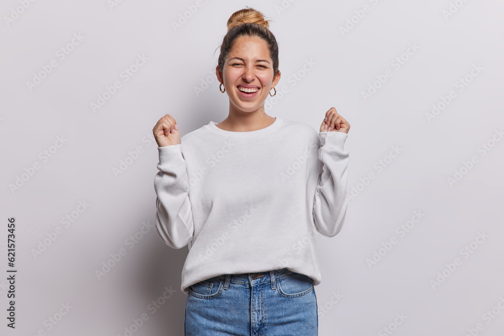 Studio shot of pretty young woman with beaming smile and eyes sparkling ...