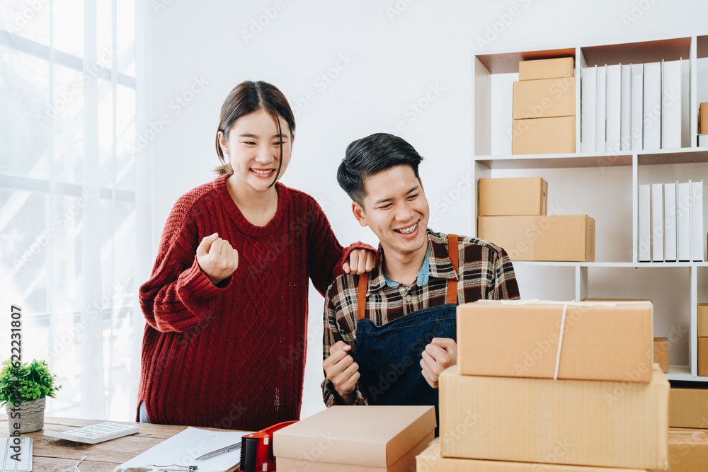 A young Asian couple shows delight and smiles on their faces when they ...
