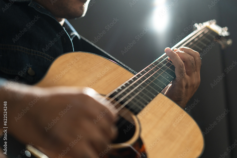 Attractive singer man singing music and playing guitar on stage with ...