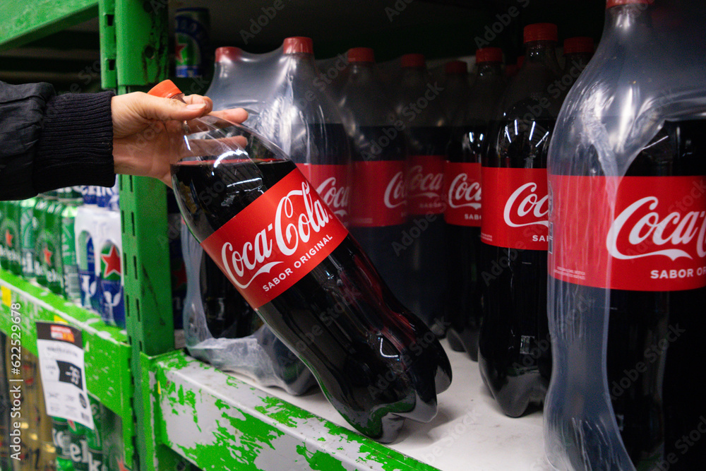 unrecognizable woman picking a coca-cola from supermarket shelve ...