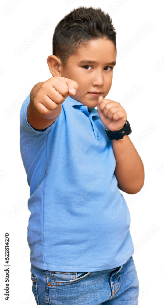 Little boy hispanic kid wearing casual clothes punching fist to fight ...