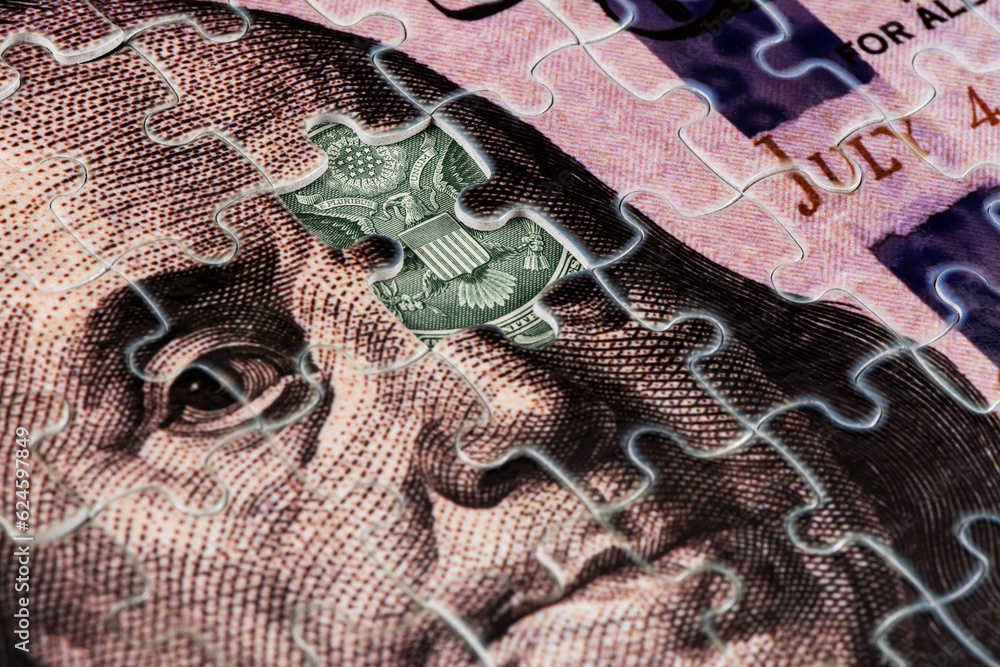 A fragment of a 100 US dollar bill assembled from puzzles and a ...
