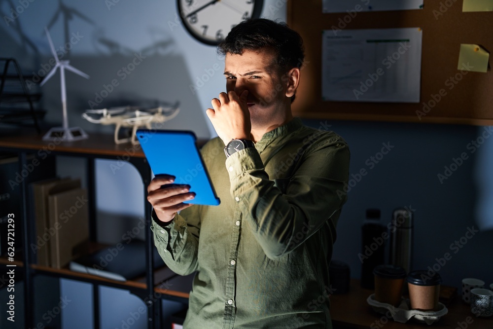 Non binary person using touchpad device at night smelling something ...