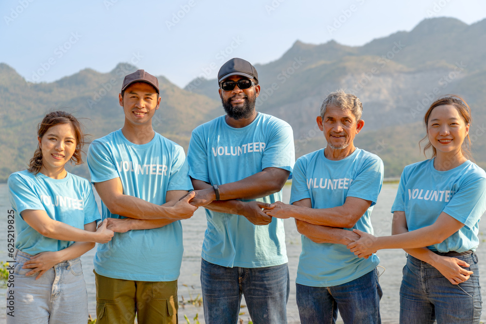 volunteer team holding each other's crossed hands for unity and ...