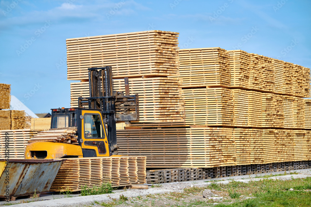Forklift loading lumber wood boards in stack, finished product ...