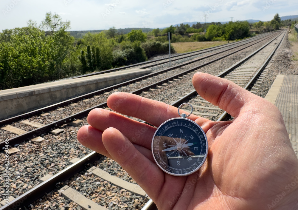Compass in hand at railway station. Tourist compass for orientation on ...
