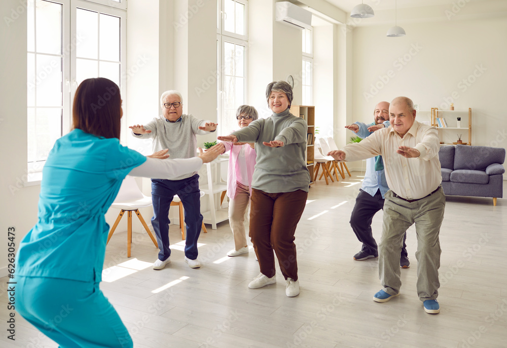 Senior group doing squat exercise with physiotherapist in gym. Elderly ...