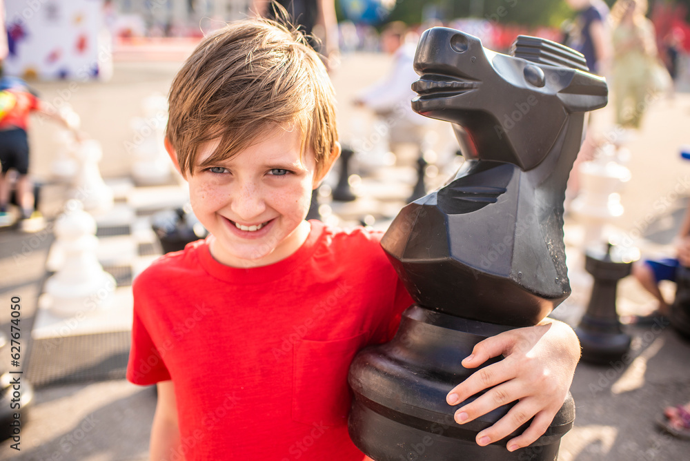 smiling boy hugging a knight chess piece. happy little chess player ...