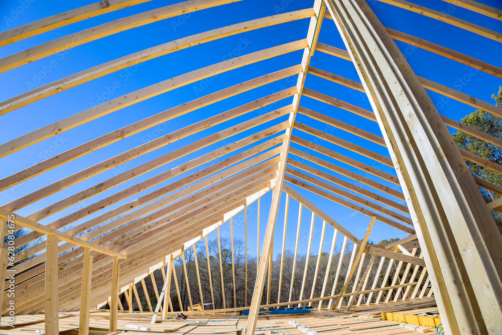 Wood frame truss roofing is constructed at new house construction site ...