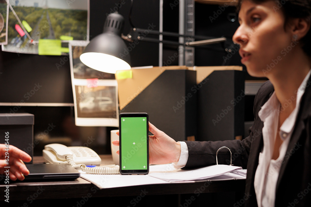 Foto Private detective holding smartphone with green screen mock up ...