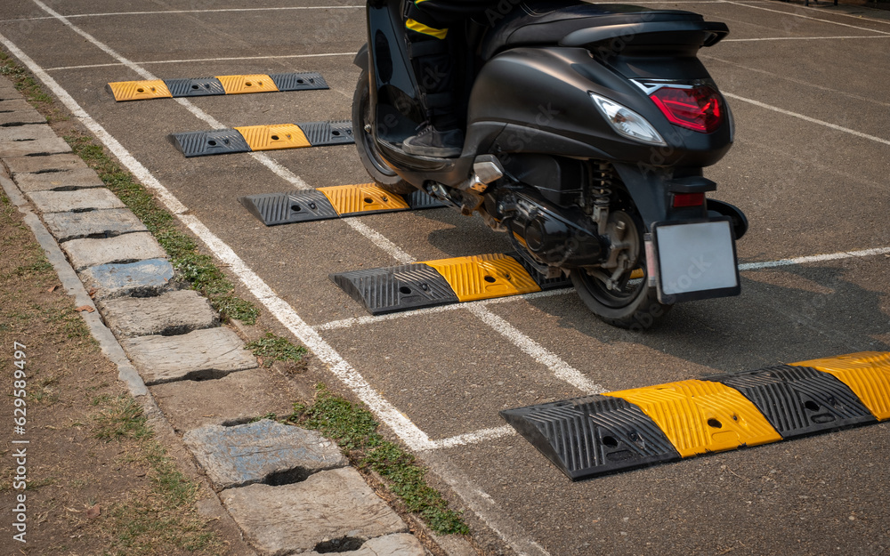 Motorcycle driving up to Speed Bump on road.Traffic safety speed bump ...