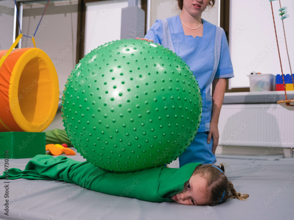 Physical therapist working with little girl in sensory room. Exercising ...