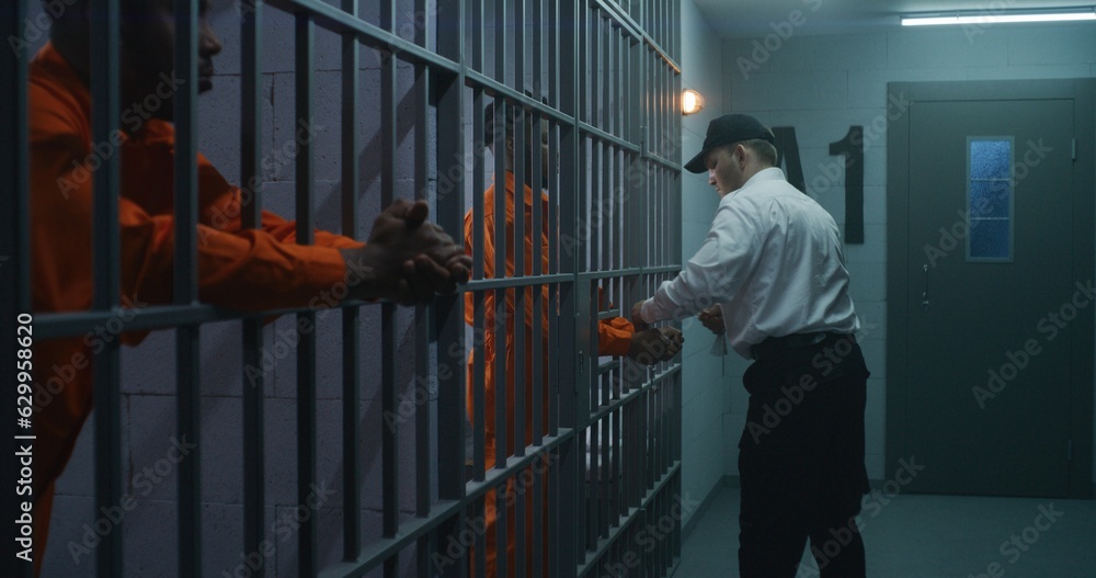 Warden brings new prisoner in jail cell and takes off his handcuffs ...