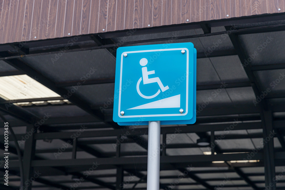 Wheelchair symbol up the slope. Blue signboard for disabled wheelchairs ...