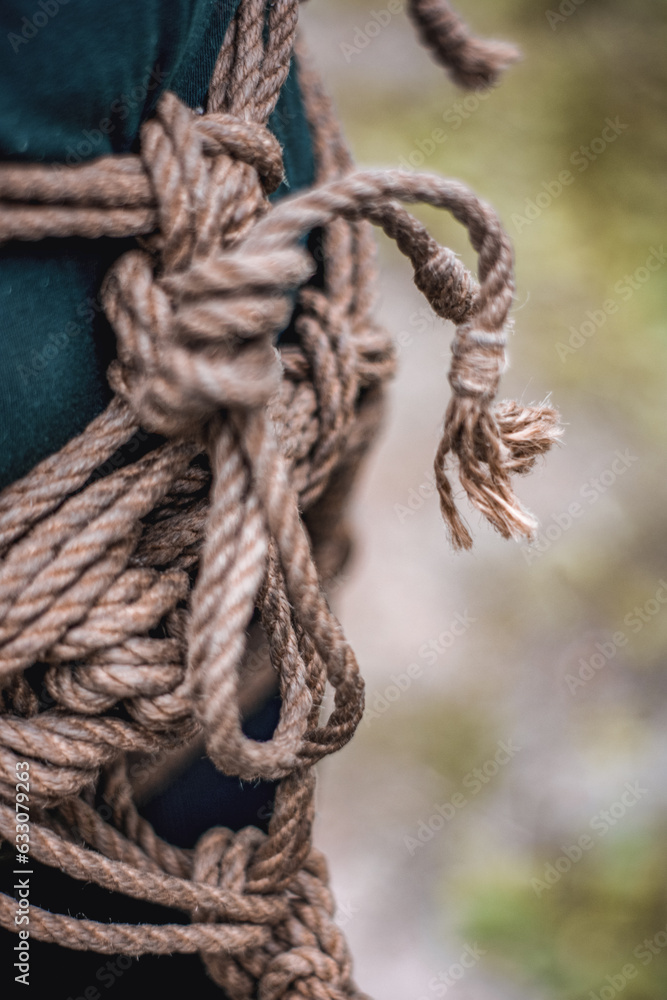 tied up woman in green body and black tights with a natural rope ...