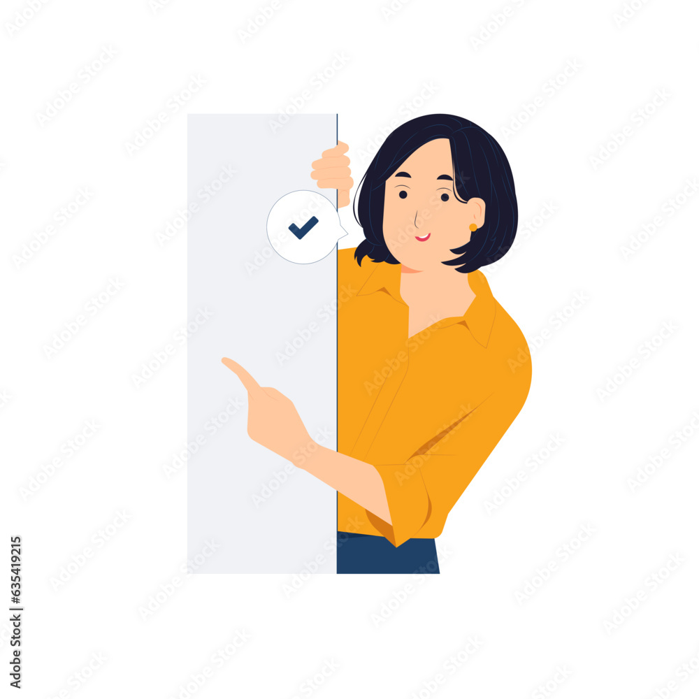 Young woman standing behind a wall while peeking and pointing finger ...