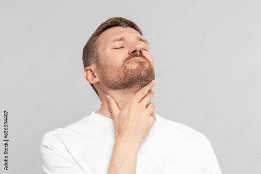 Man touch neck, suffering from sore throat. Sick male suffers from ...