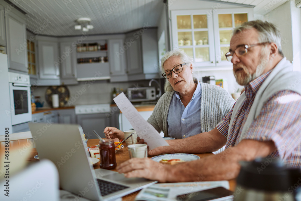 Senior couple going over their bills and home finances while having ...