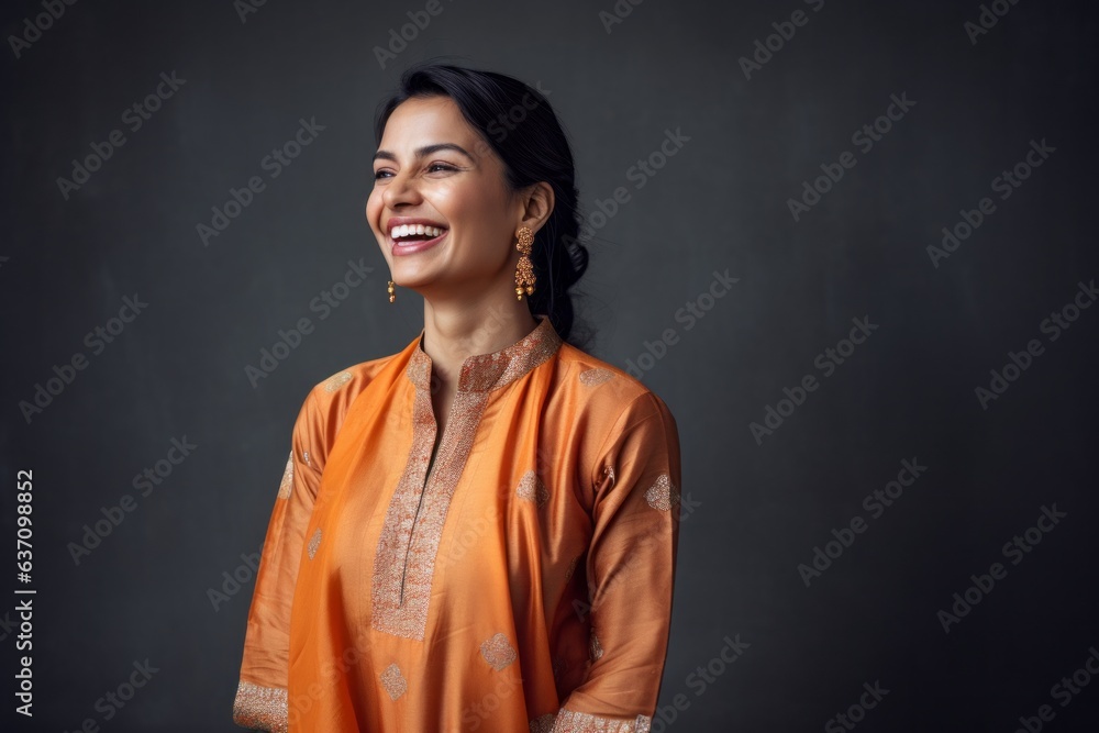 Lifestyle portrait of an Indian woman in her 30s wearing sherwani in a ...