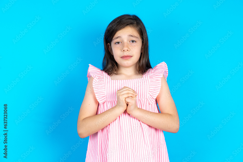 Photo Stock Sad caucaisna kid girl wearing pink dress over blue ...