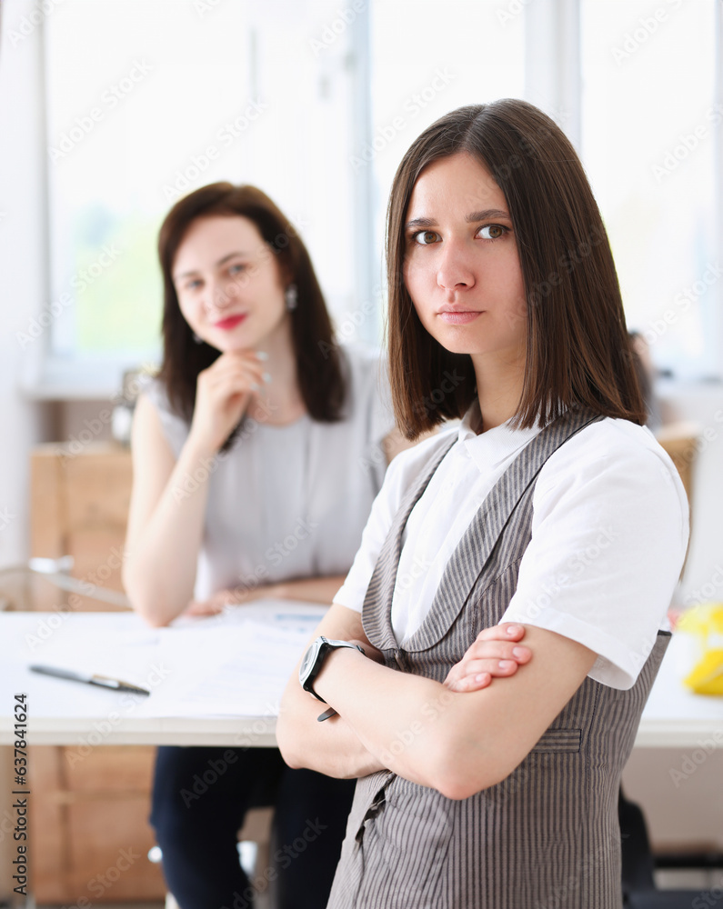 Beautiful girl at workplace with ars crossed colleagues group in ...