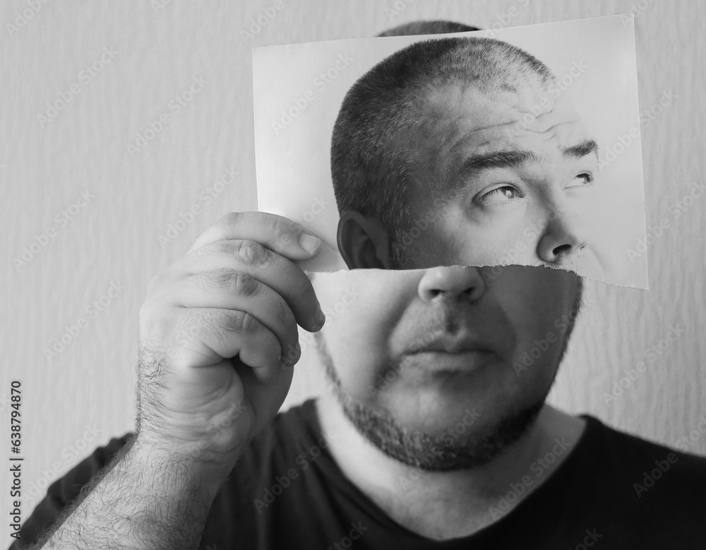 Portrait of a man holding a piece of white paper behind eyes. isolated ...