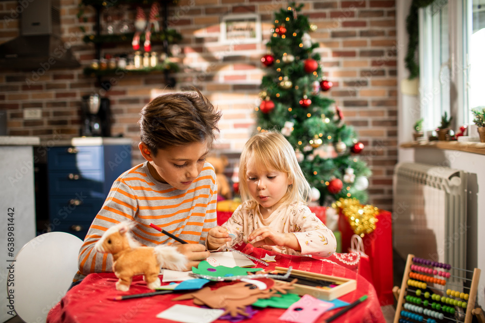 Young brother and sister writting a letter to santa claus in a living ...