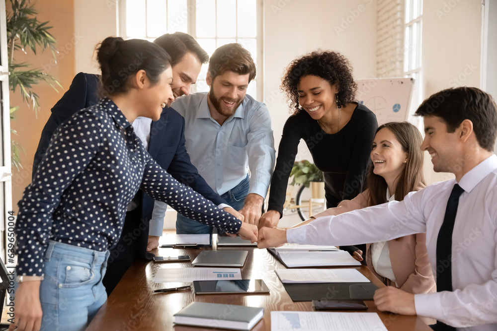 Overjoyed young multiracial colleagues give fist bump motivated for ...