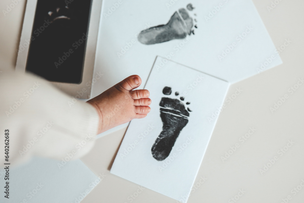 Baby footprints on white paper. Black footprint. The process of ...