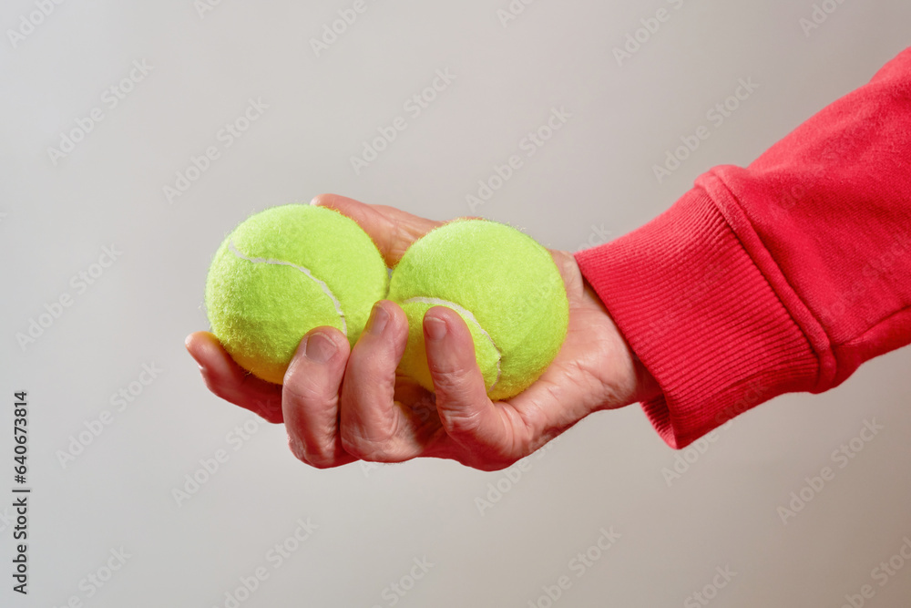 Tennis ball in the hand of an elderly woman. Senior female wrinkled ...